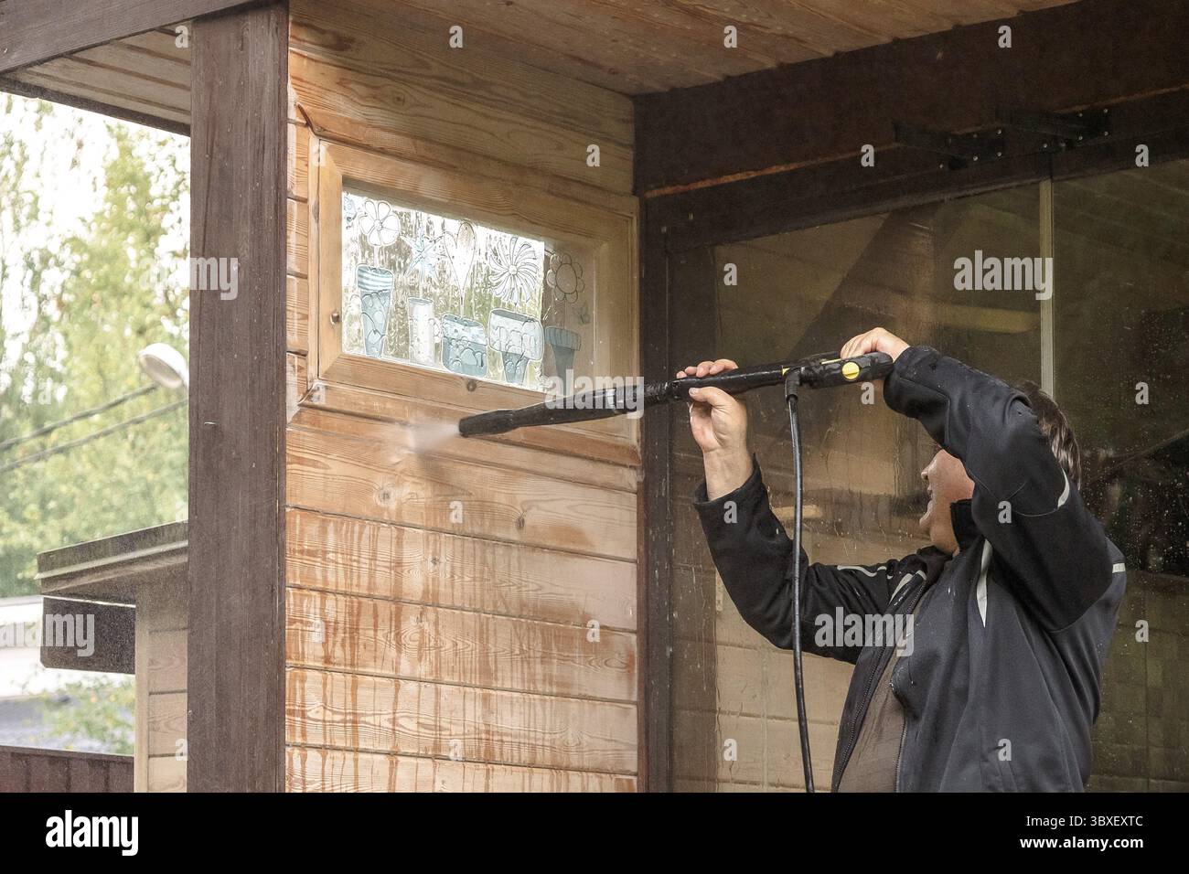 Man cleaning walls and floor with high pressure power washer. Washing ...