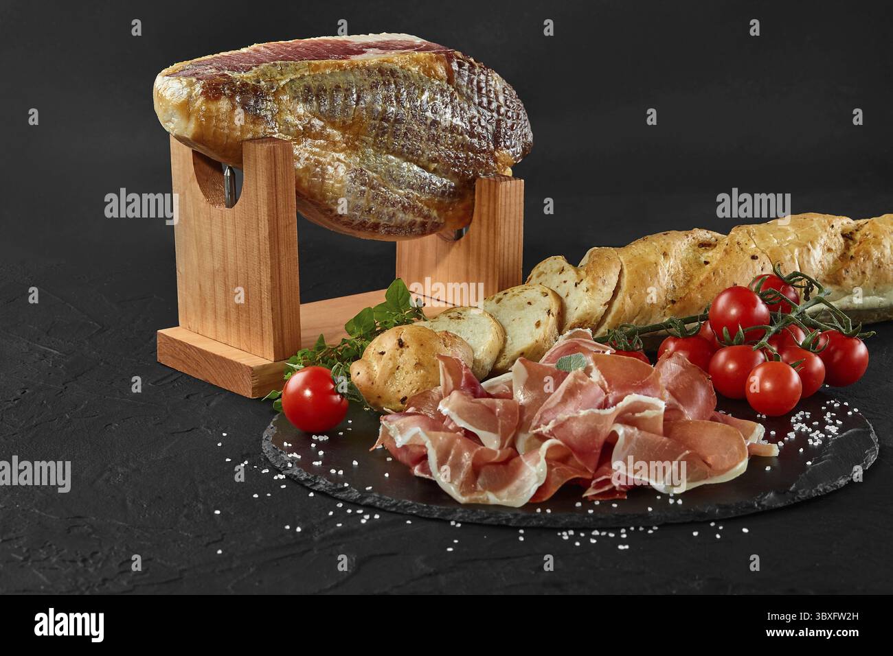 Gourmet jamon manually carved from pig leg on a jamonera stand, cherry ...
