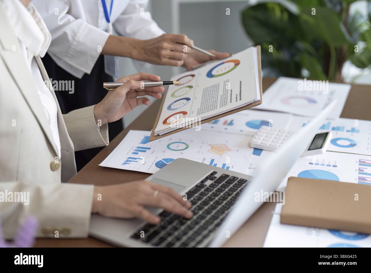 Reviewing business statistic charts on hi-res stock photography and ...