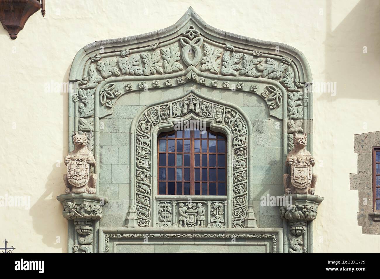 An exterior portal topped by a Tudor-style arch with two lions ...