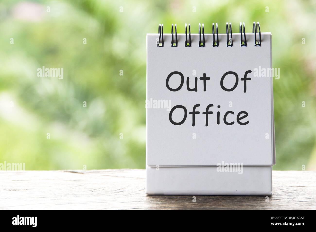 Out Of Office text on white notepad with blurred nature background ...
