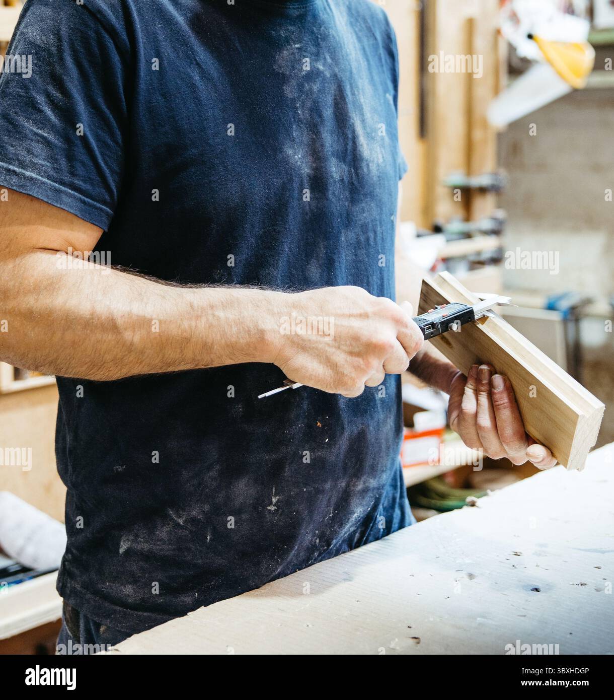Detail of manual wood measurement using caliper in woodworking workshop ...