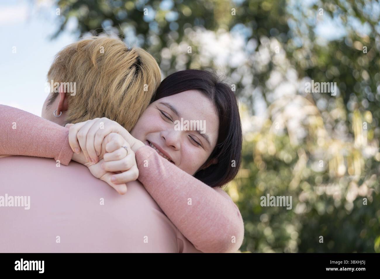 A loving couple shares a heartfelt embrace in a serene outdoor setting ...
