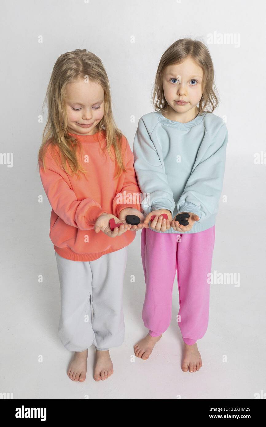 Two cheerful pretty girls hold in their hands letters with word LOVE ...