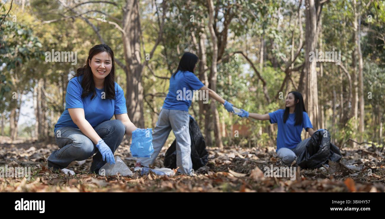 Volunteer collecting plastic trash in the forest. The concept of environmental conservation ...