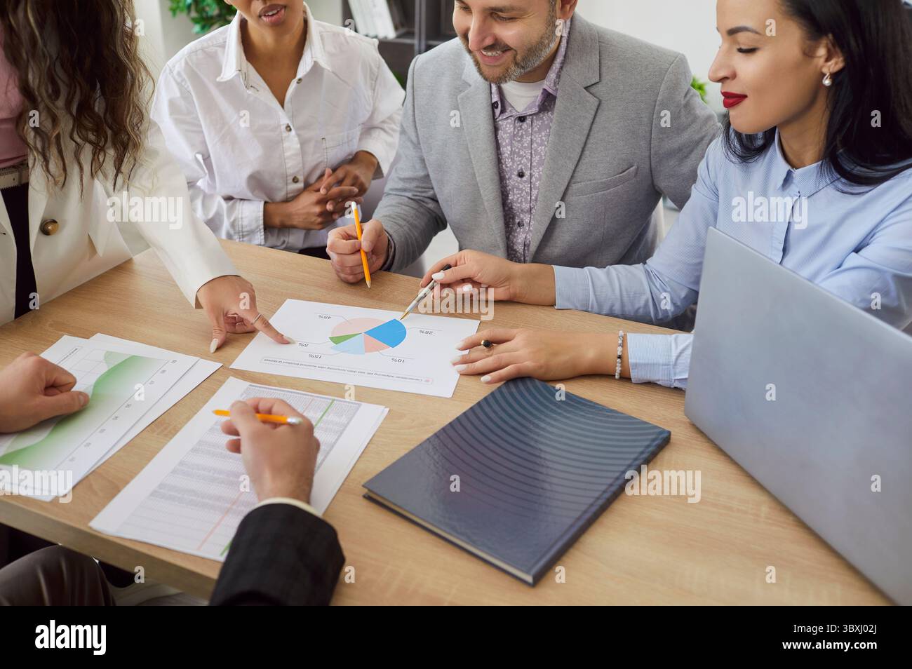 Diverse group of professionals sitting around table in office setting ...