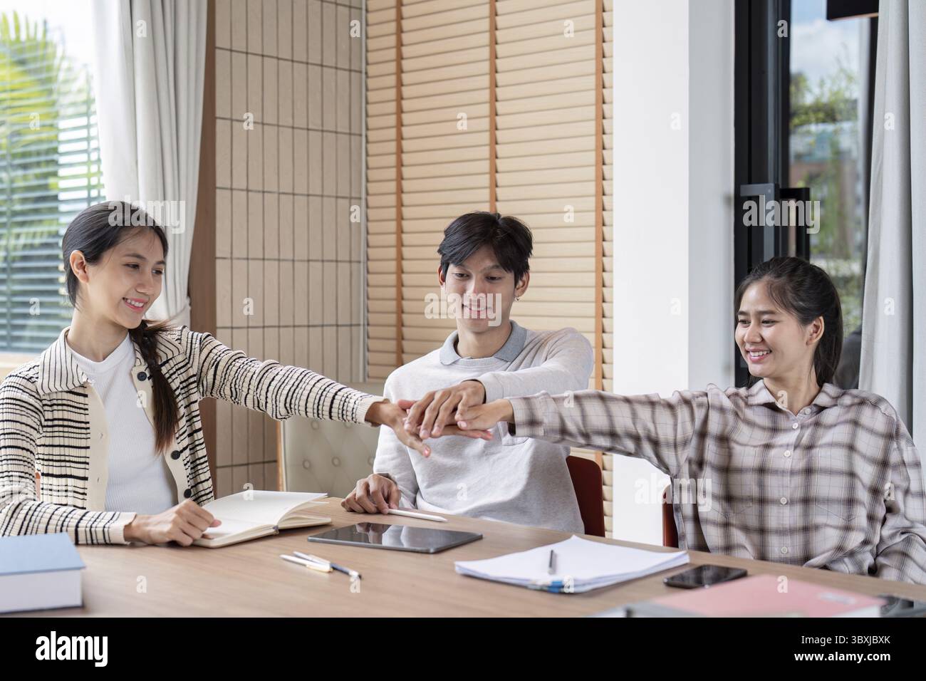 Three students working together, sharing ideas, and studying in a ...