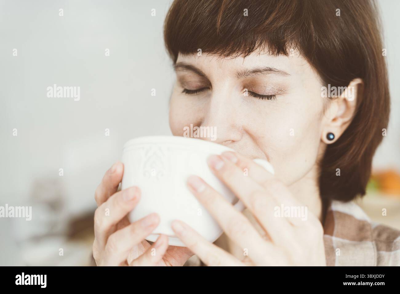 COVID-19 causes loss of smell. Woman sniffing smell of coffee from cup ...