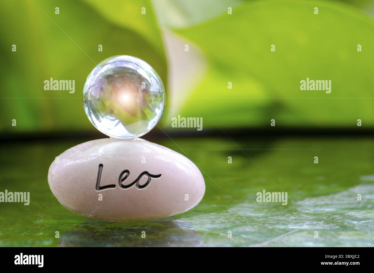 Leo text engraved on Zen stone with shining glass marble on top. Zodiac ...