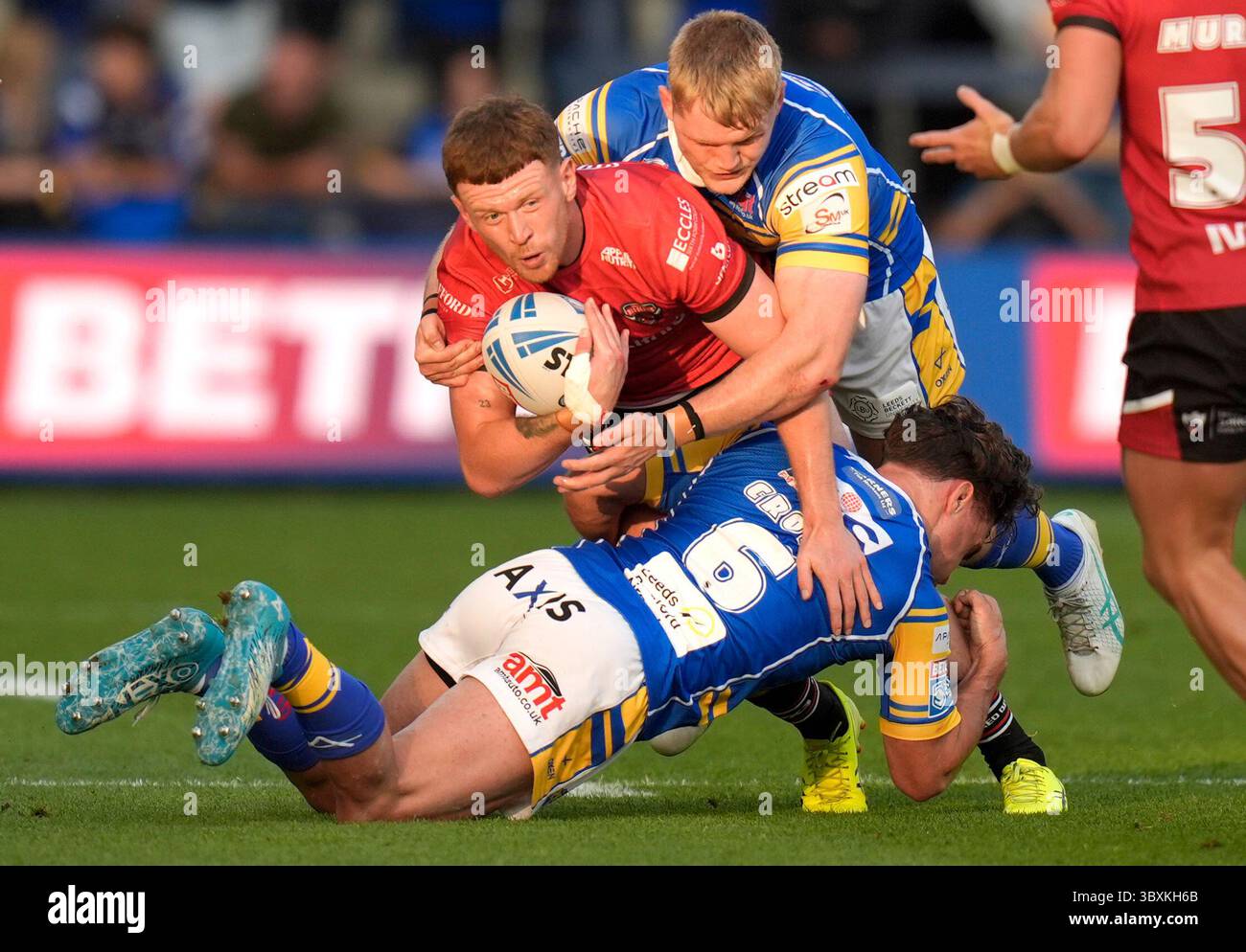 Salford Red Devils' Oliver Rusell is tackled by Leeds Rhinos' James ...