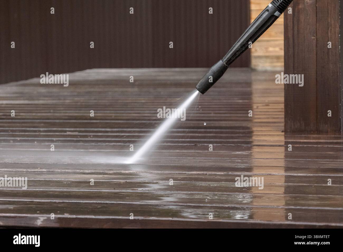 Man cleaning walls and floor with high pressure power washer. Washing ...