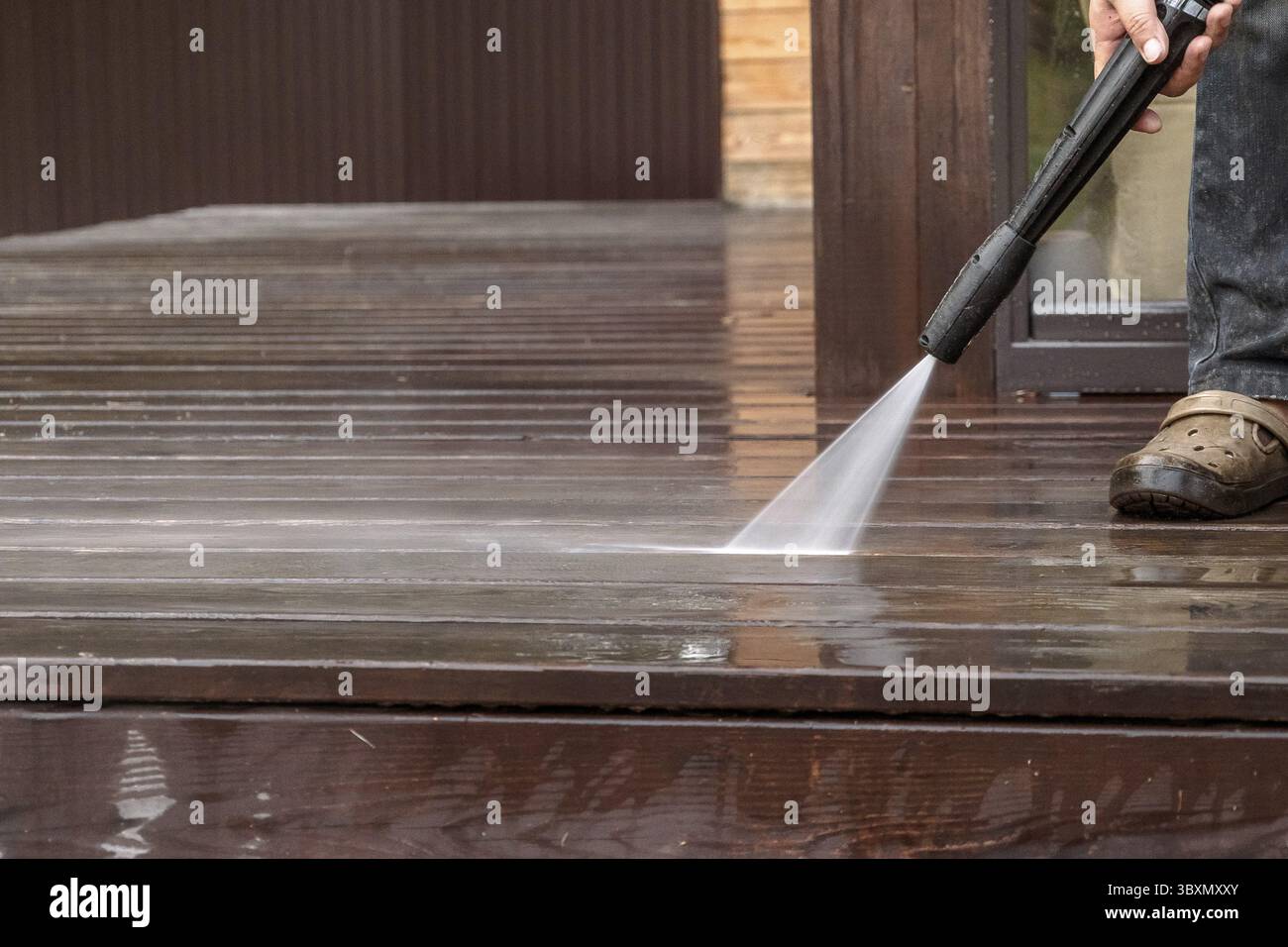 Man cleaning walls and floor with high pressure power washer. Washing ...