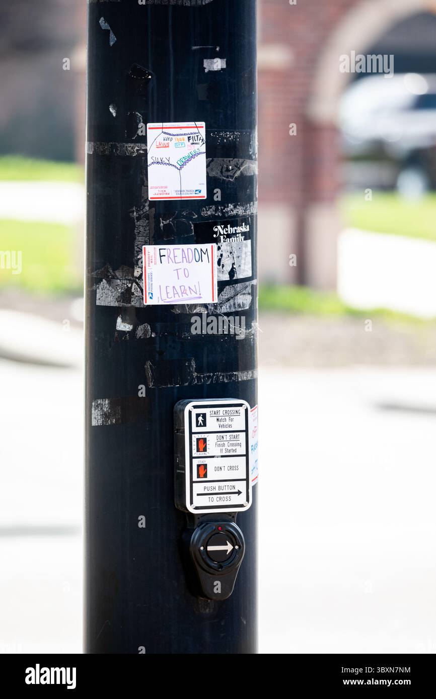 Protest stickers, made with USPS address labels, on a light pole with a ...