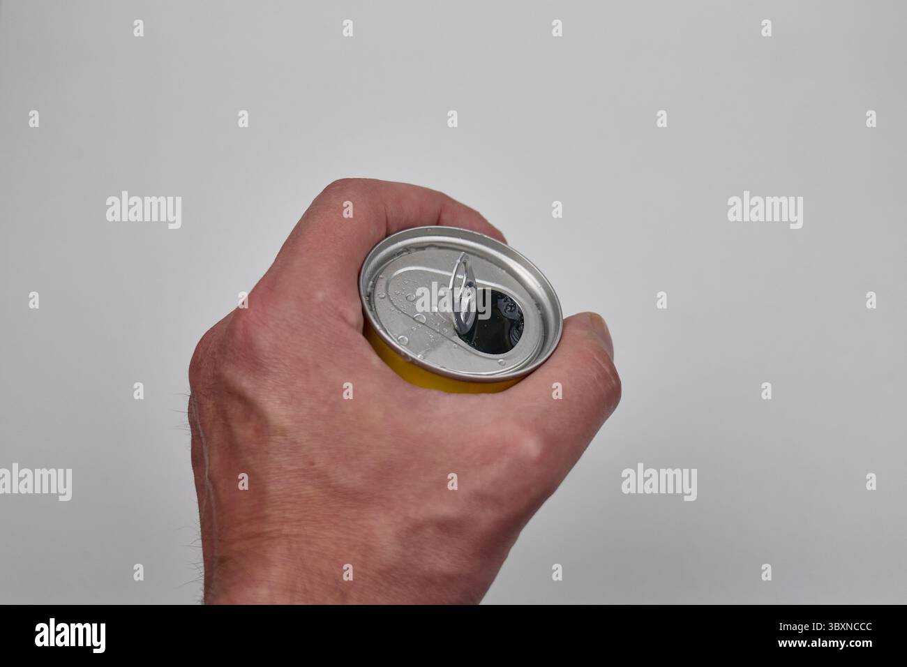 A hand grips a opened soda can Stock Photo - Alamy