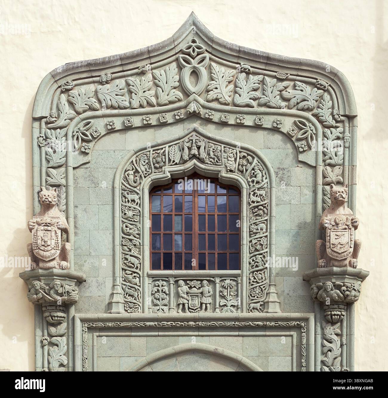 An exterior portal topped by a Tudor-style arch with two lions ...