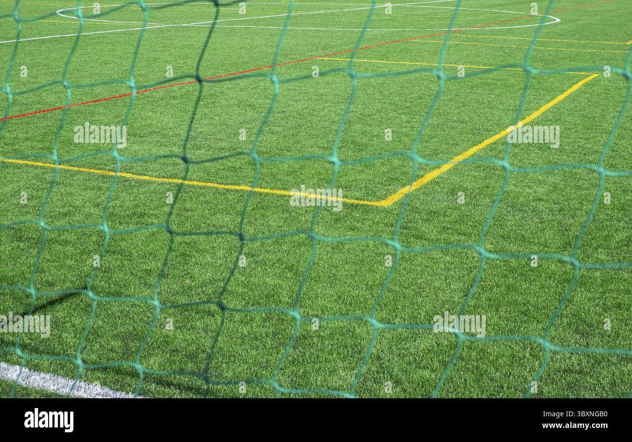 Football field with natural grass seen through the net Stock Photo - Alamy