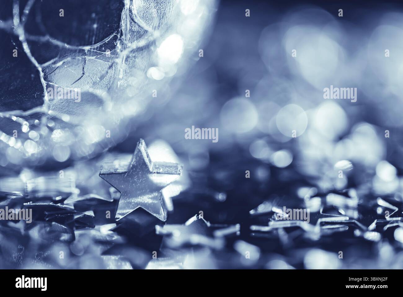 Macro photo of bright silver star and cracked glass sphere with light ...