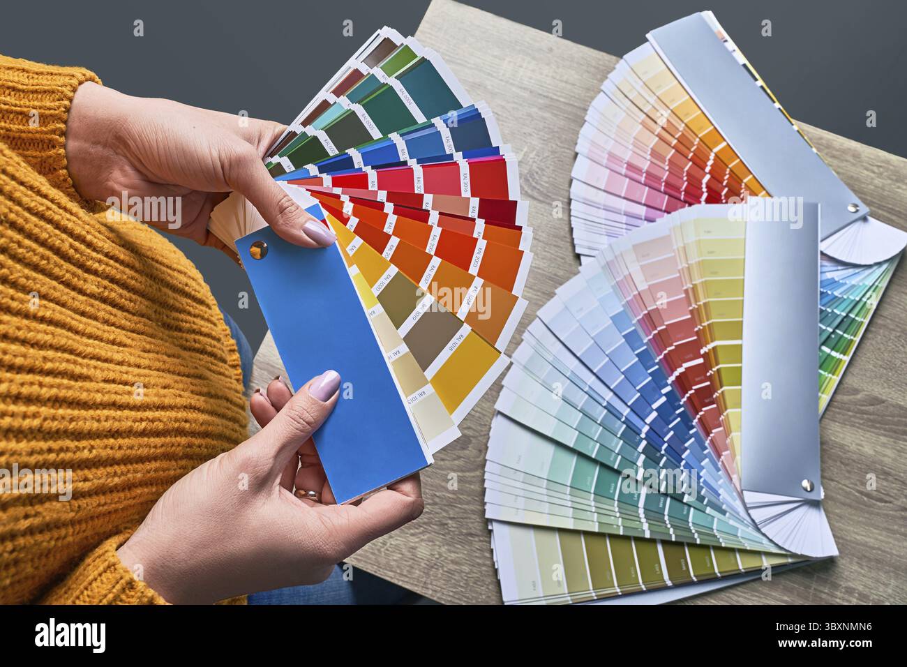Color wheel for choosing paint tone. Hands of female interior designer ...