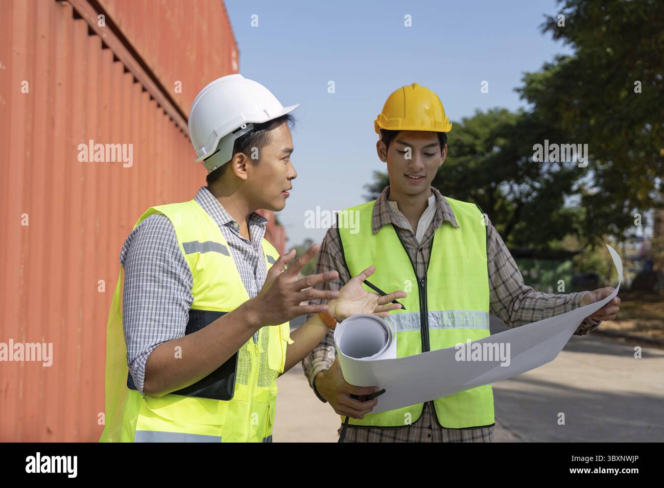 Two engineers work together on logistics strategies, examining ...