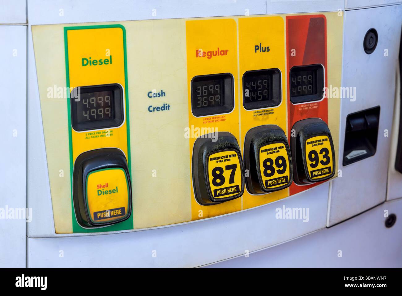 Fuel dispensers show various fuel types, prices while drivers refuel ...