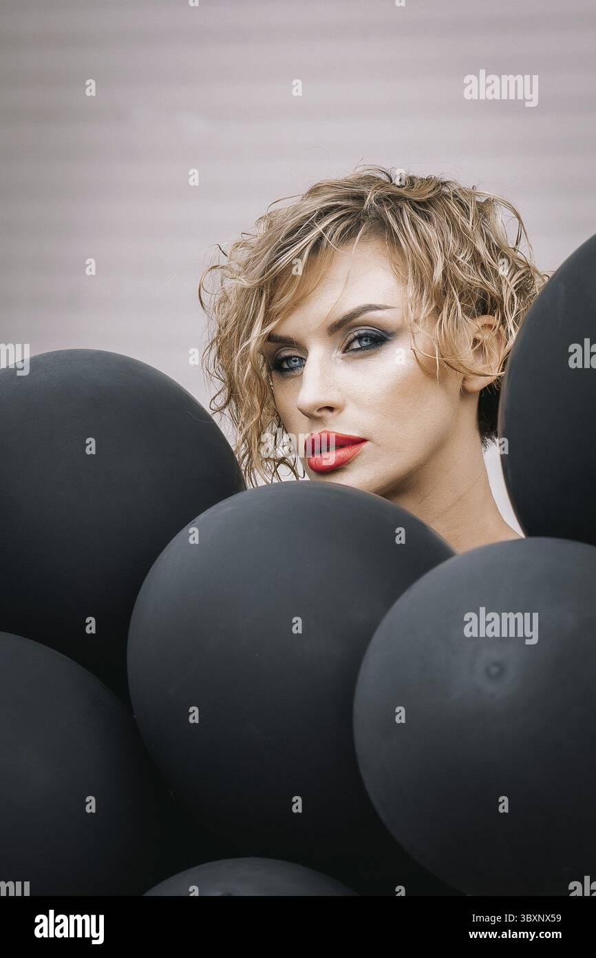 Portrait beautiful woman of model appearance with dark balloons. Art ...