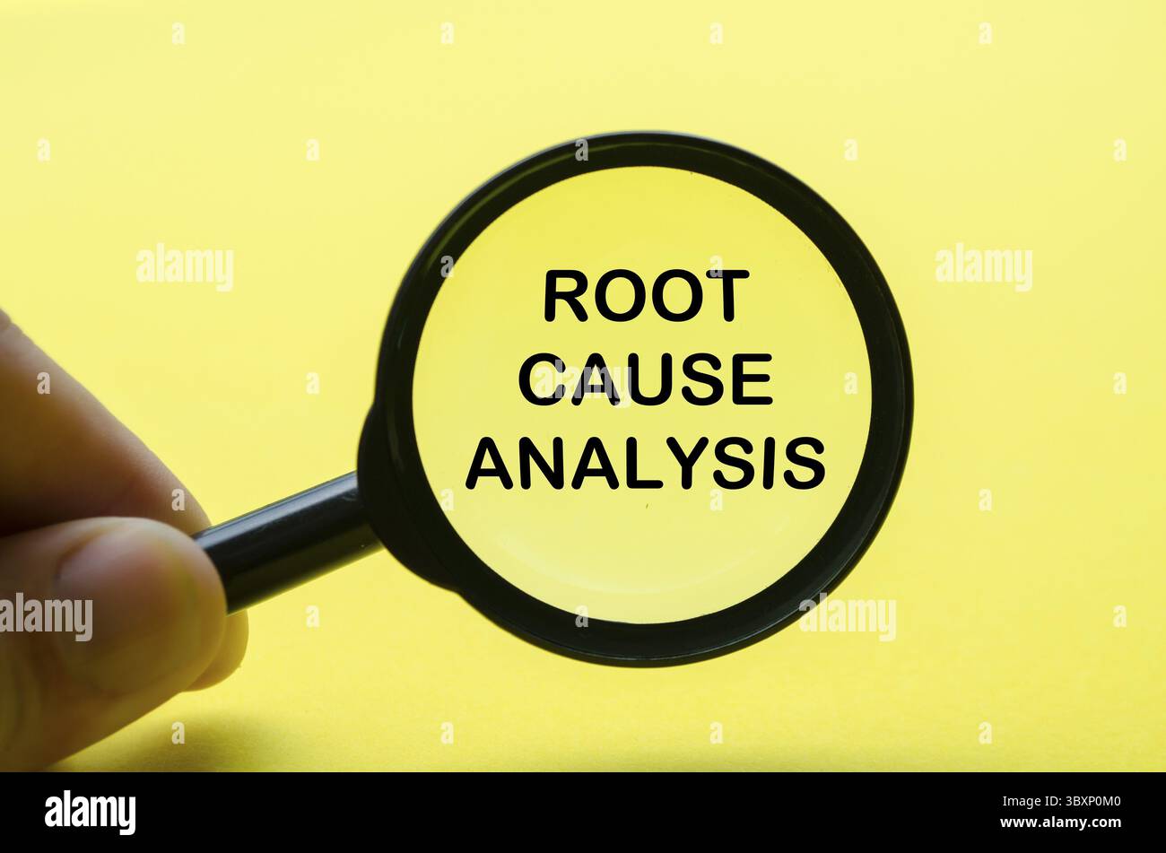 Hand holding magnifying with Root Cause Analysis text on yellow ...