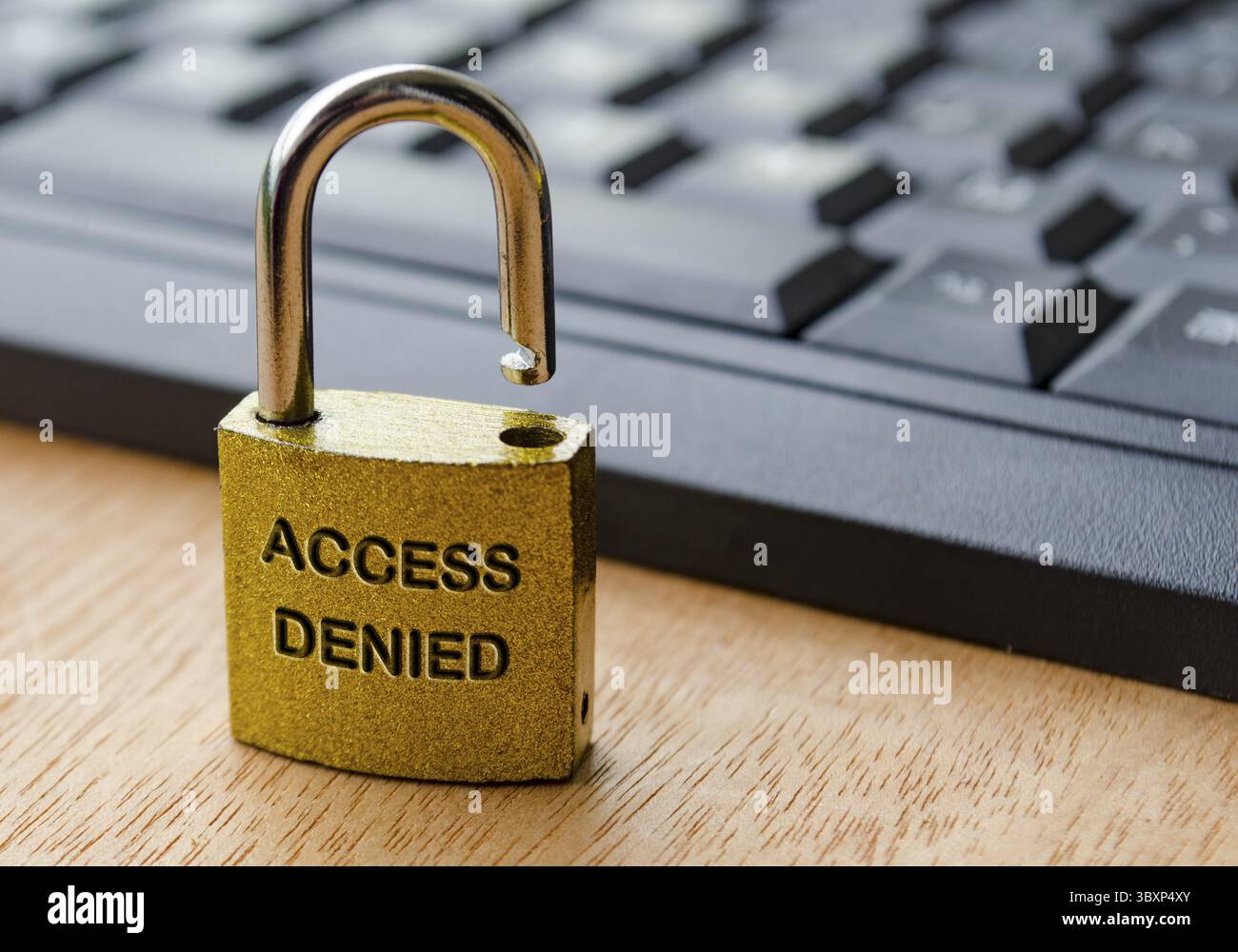 Access Denied text engraved on padlock with keyboard background ...