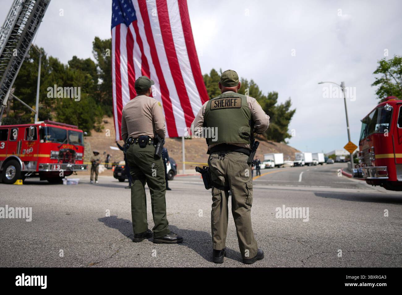 Sheriff's deputies stand along a procession route near where an ...