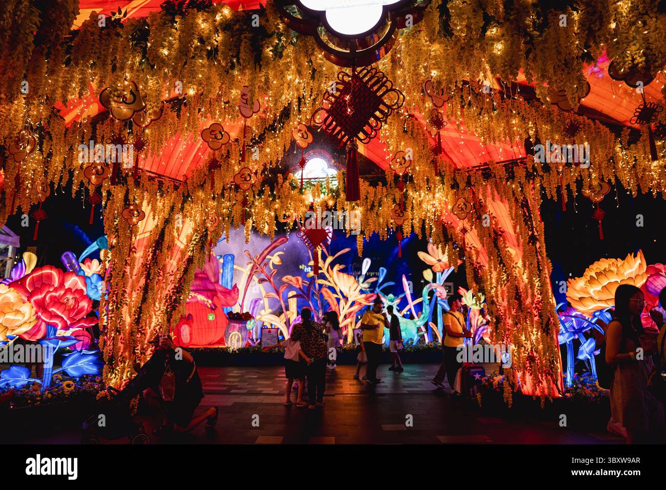 Lantern-lit arches adorned with cascading flowers welcome visitors into ...