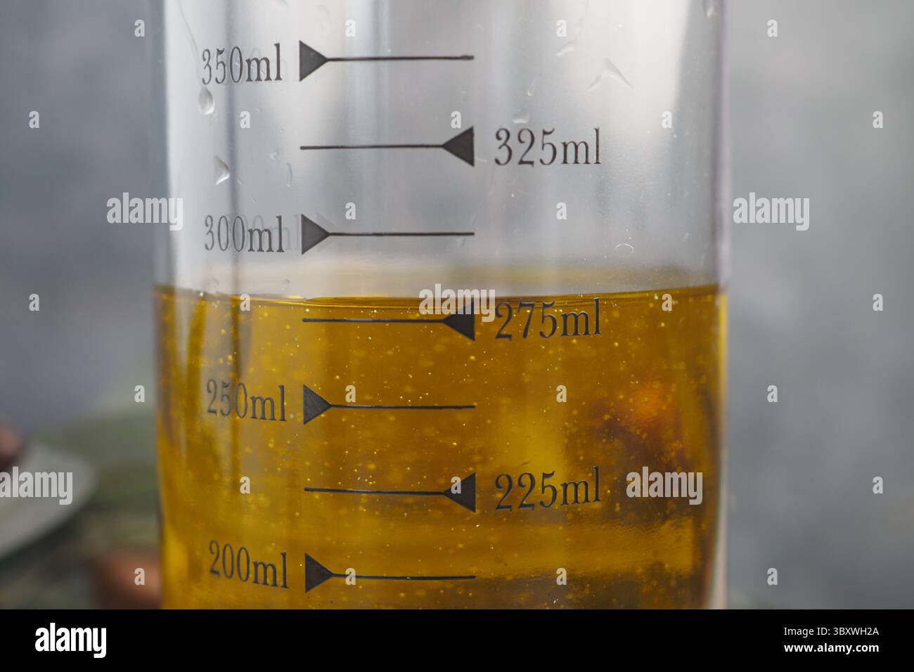 Measuring oil for cooking in a clear container with markings Stock ...