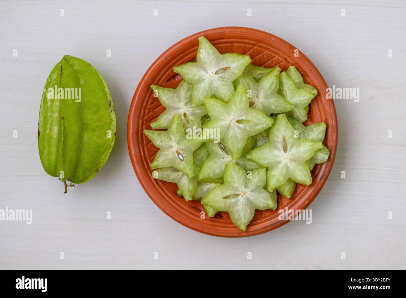 Vibrant, freshly sliced star fruit (Averrhoa carambola), known as ...