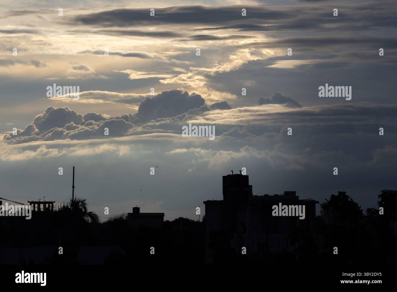 Beautiful dark cloudy sunset with a striking cityscape silhouette ...