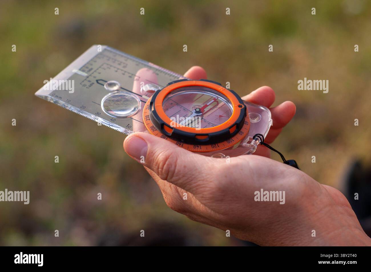 Hand Holding Navigation Compass with Transparent Map Ruler Outdoors ...