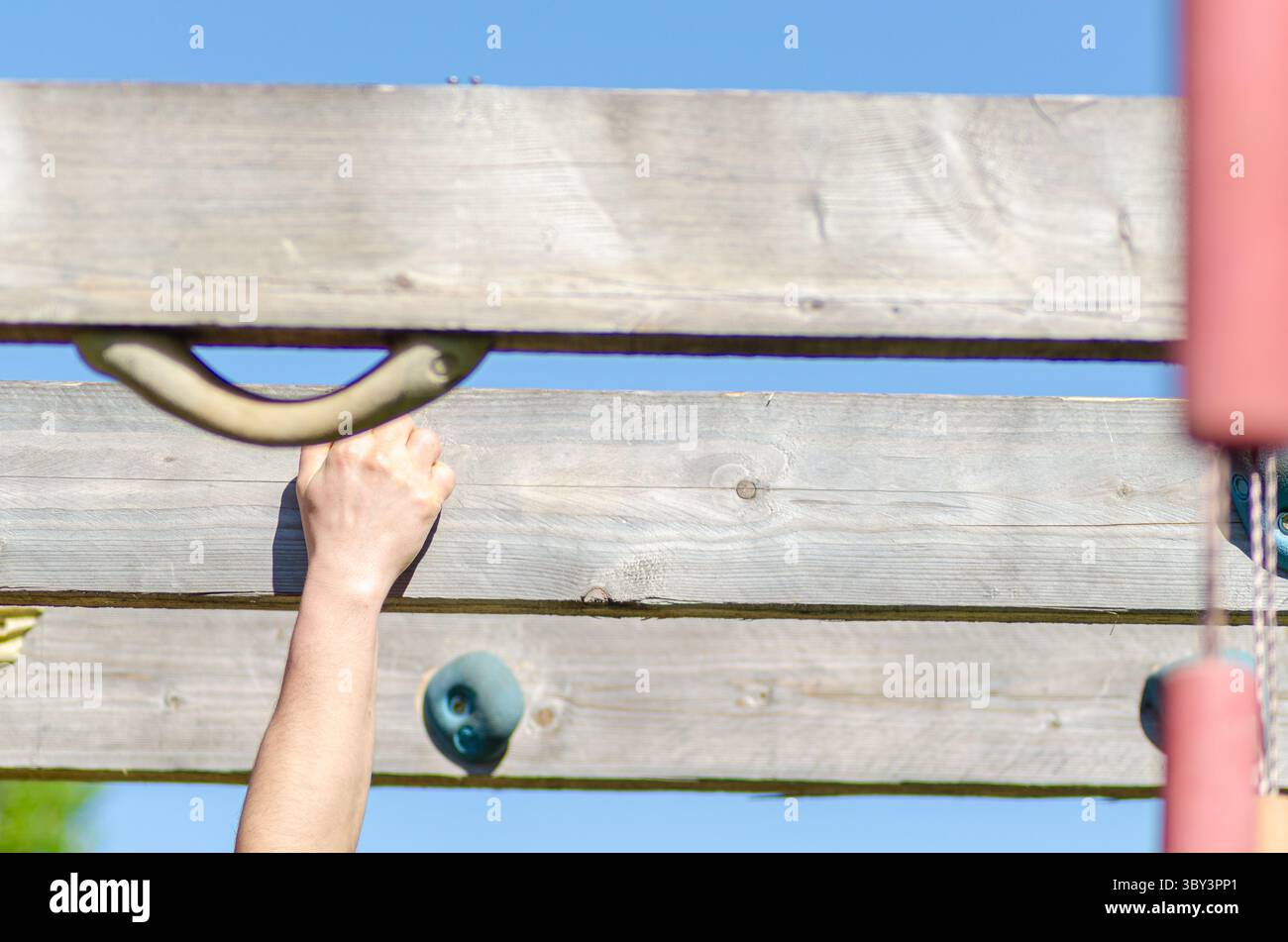 Hand gripping a wooden beam on a climbing wall structure Stock Photo ...