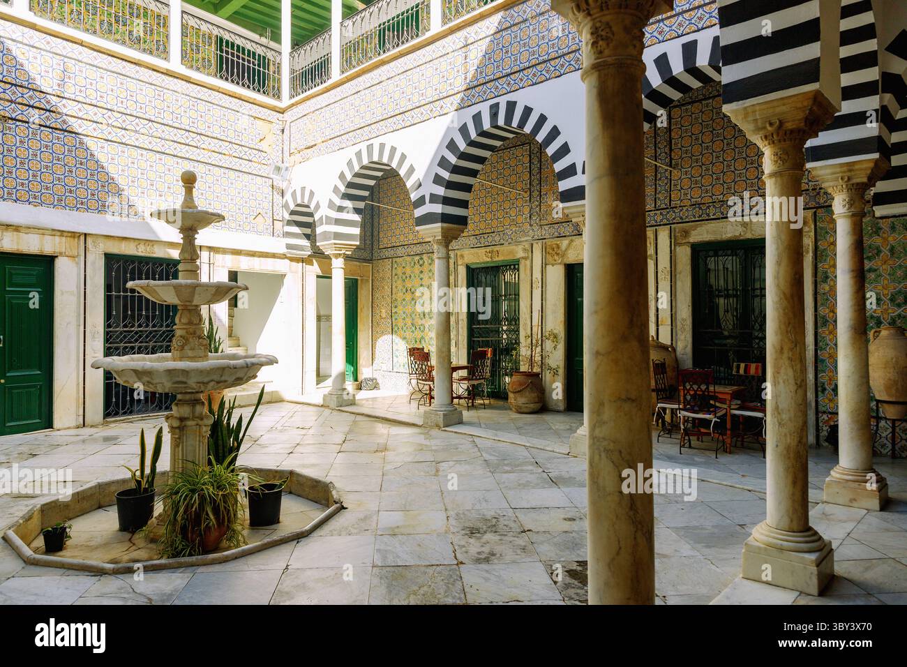 Courtyard decorated with tiles, fountains, and colorful columned ...