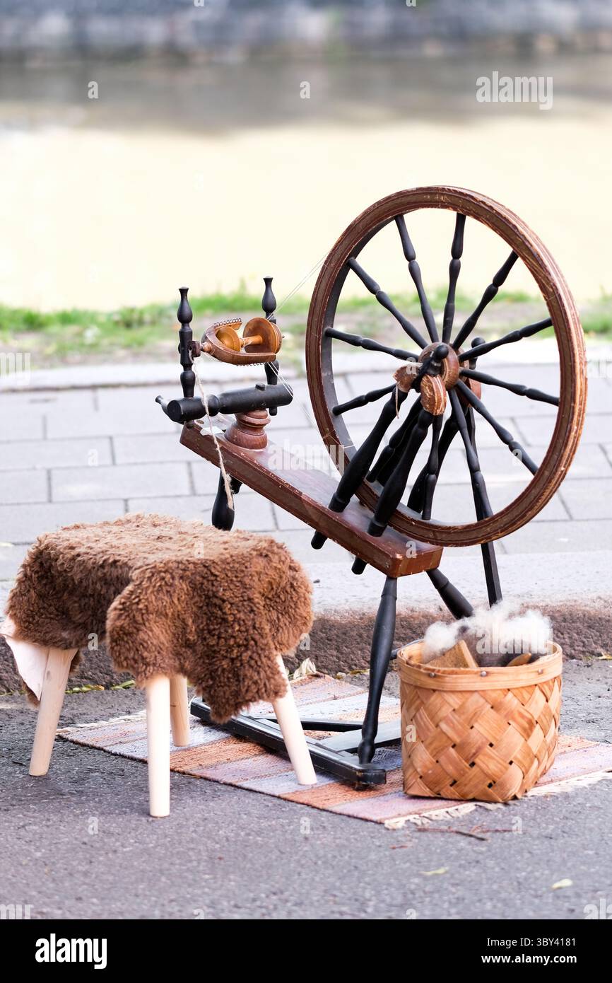 An old spinning wheel with a chair Stock Photo - Alamy