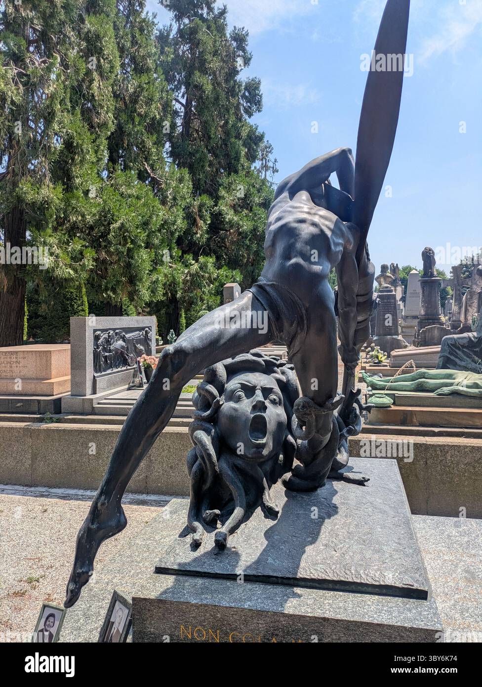 statue of a man towering over medusas head in graveyard Stock Photo - Alamy
