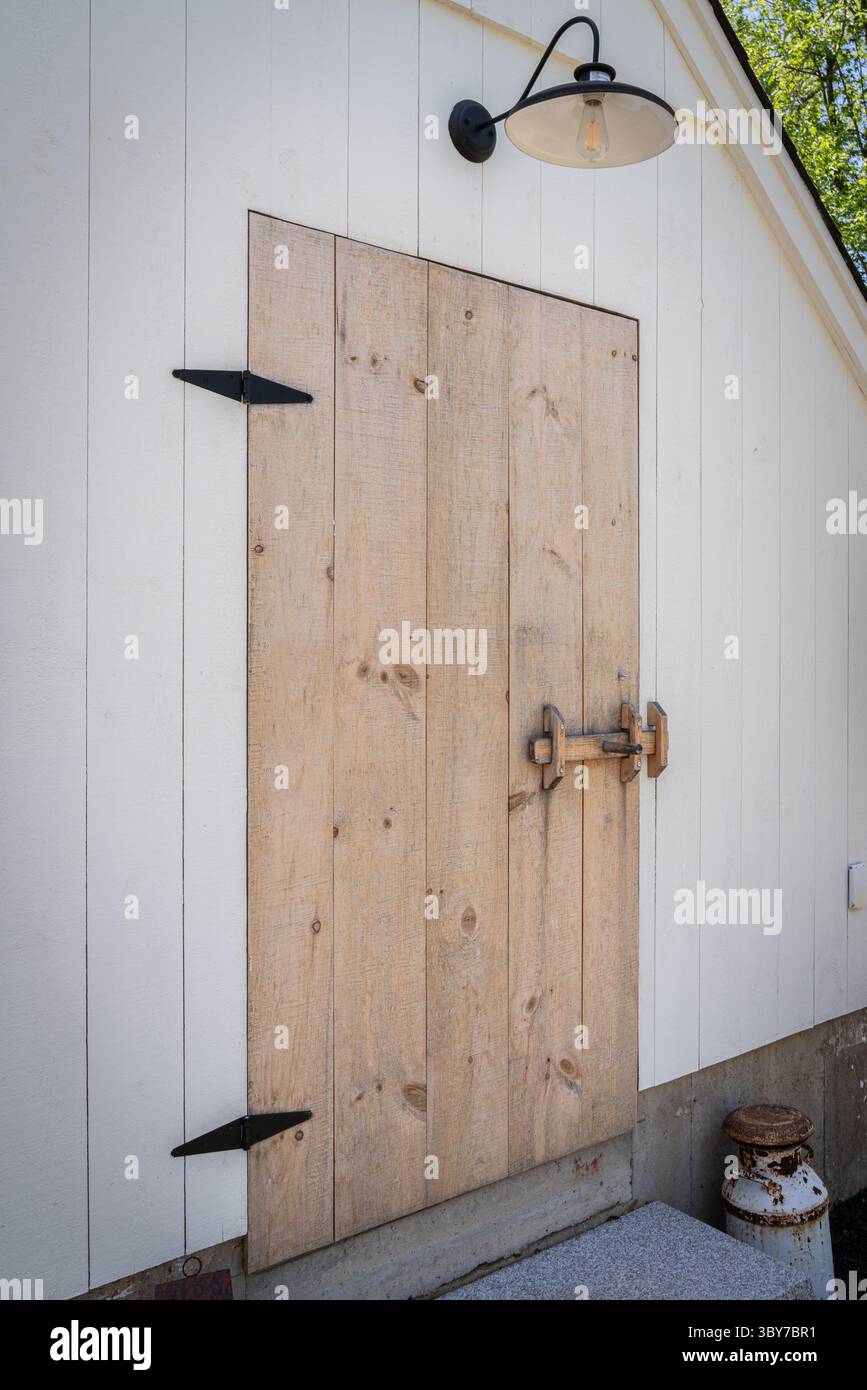 Close-up of a weathered wooden barn door with black hardware and a ...