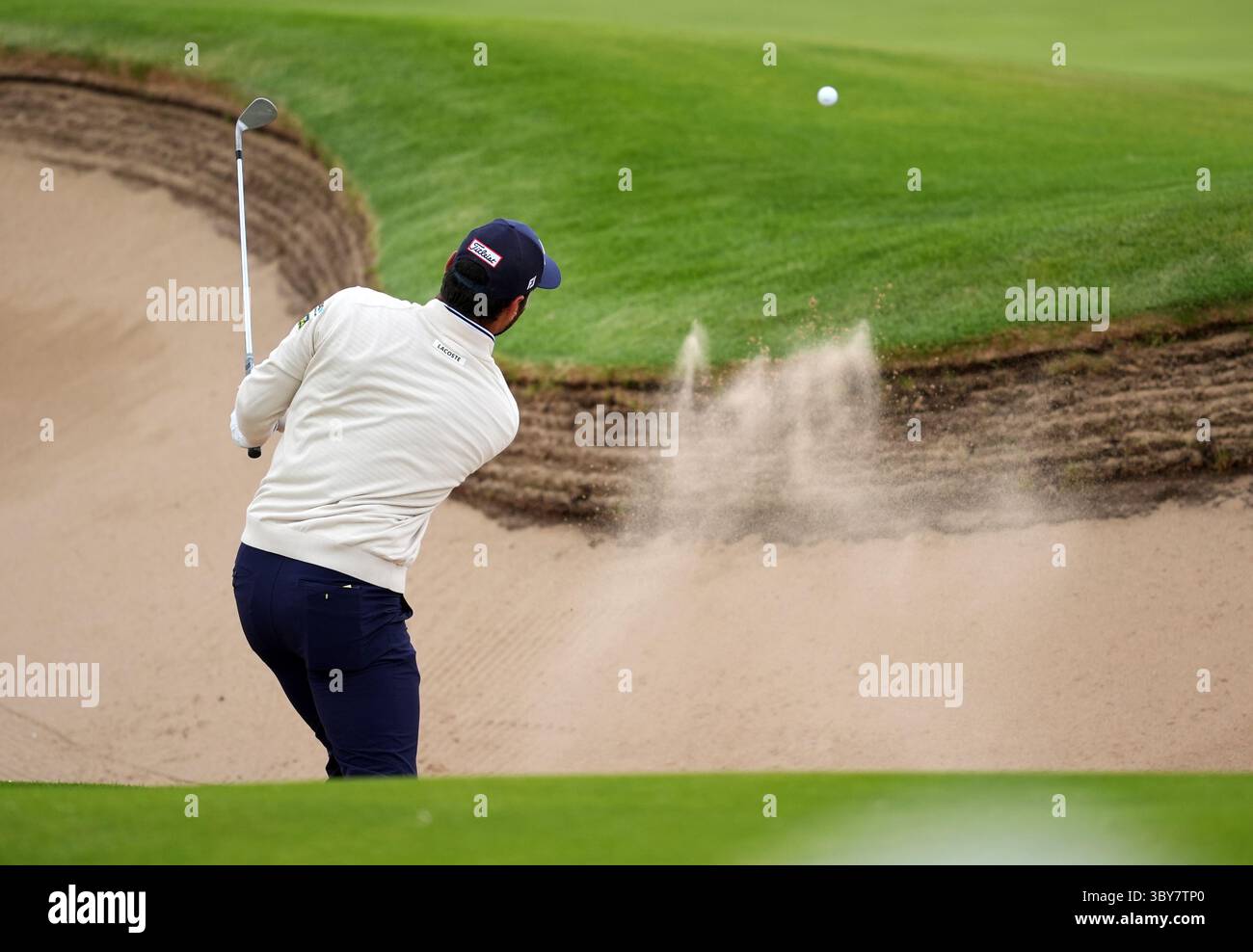 France's Antoine Rozner chips out of a bunker on the 13th during day ...