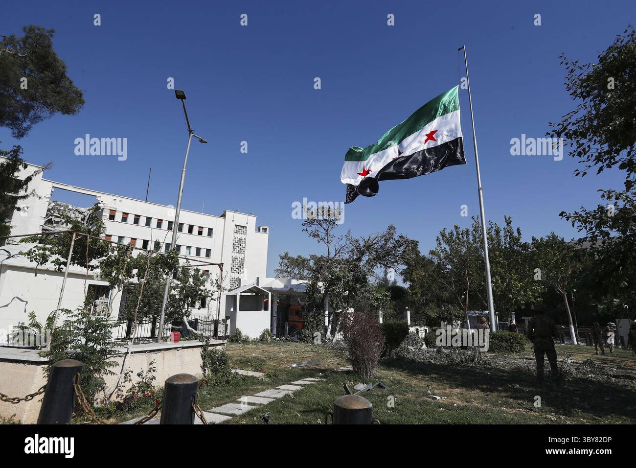 Syrian soldiers raise the Syrian national flag in front of the Syrian ...