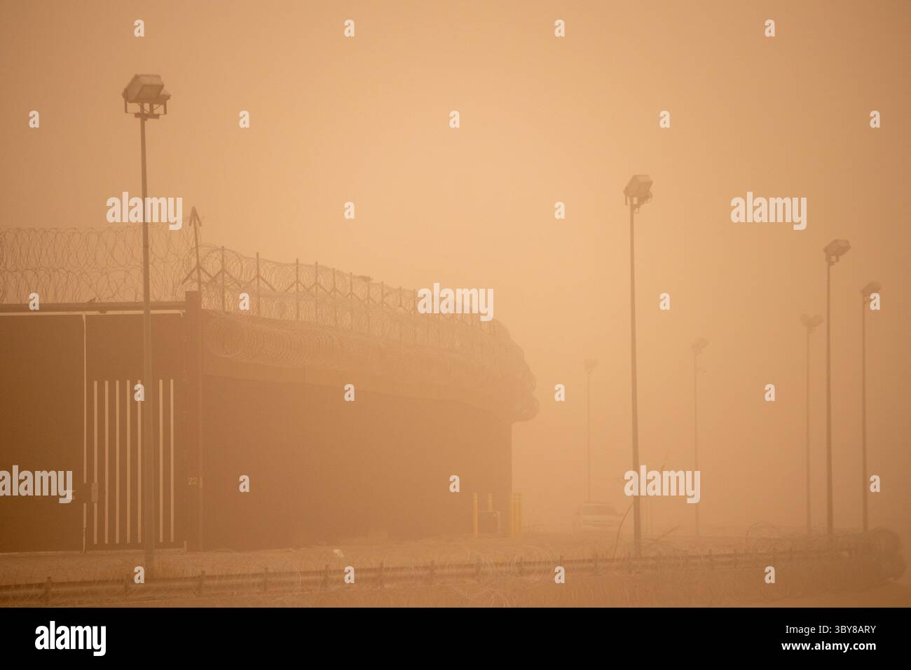 A fortified facility near Ciudad Juarez, obscured by sand haze ...