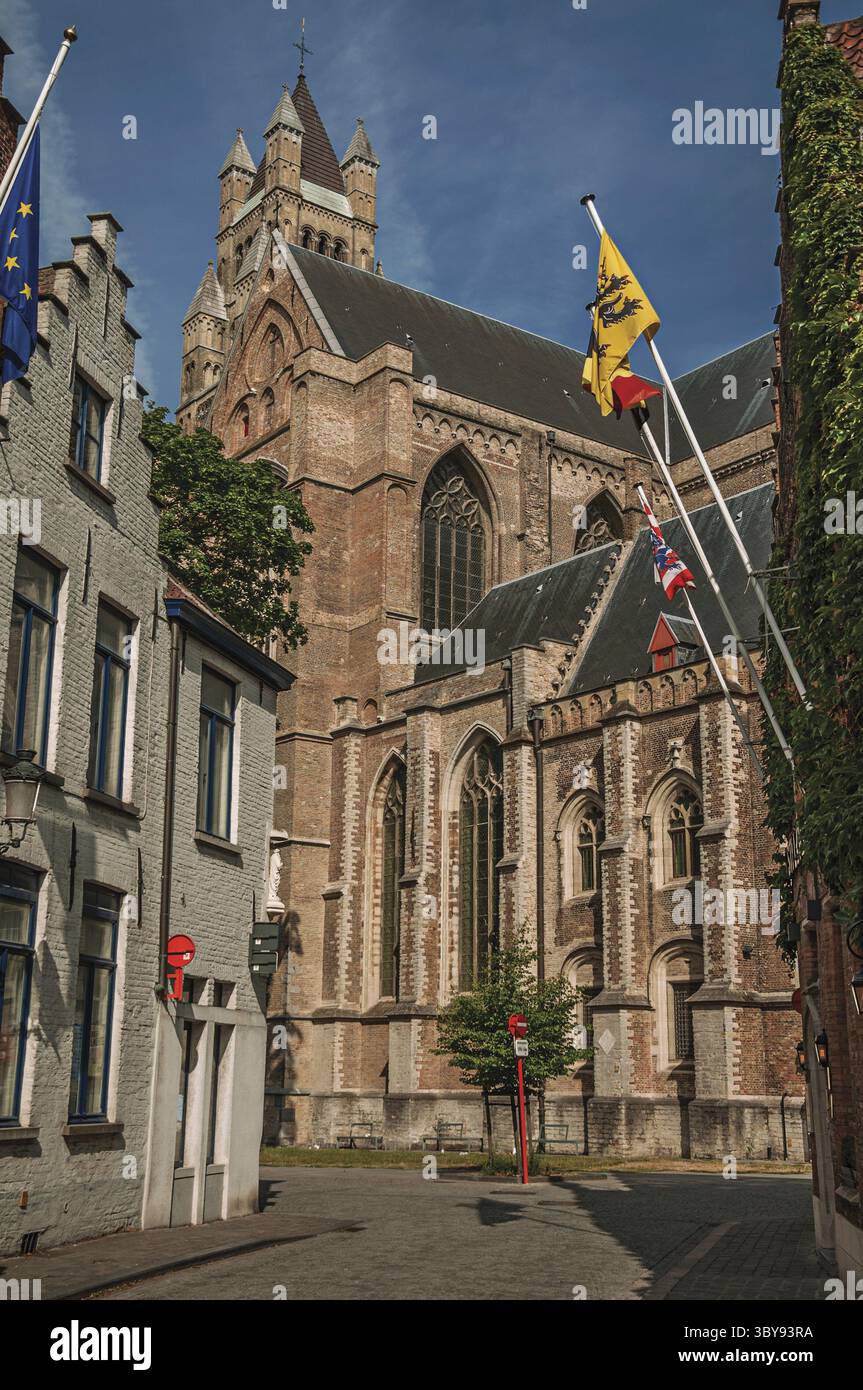 Cobblestone street with brick houses and church in Flanders style and ...