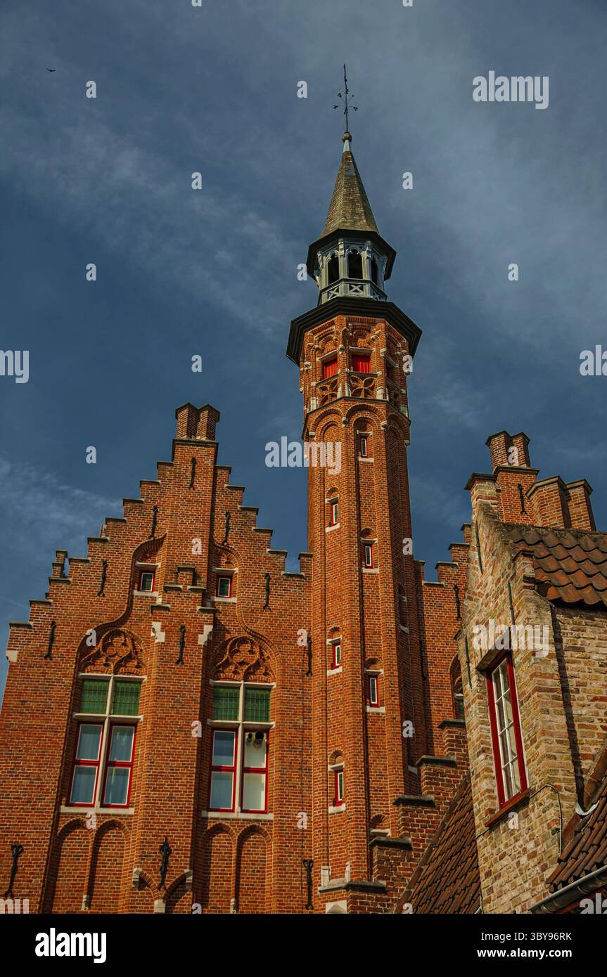 Brick facade of building and tower in Flanders and blue sky in Bruges ...