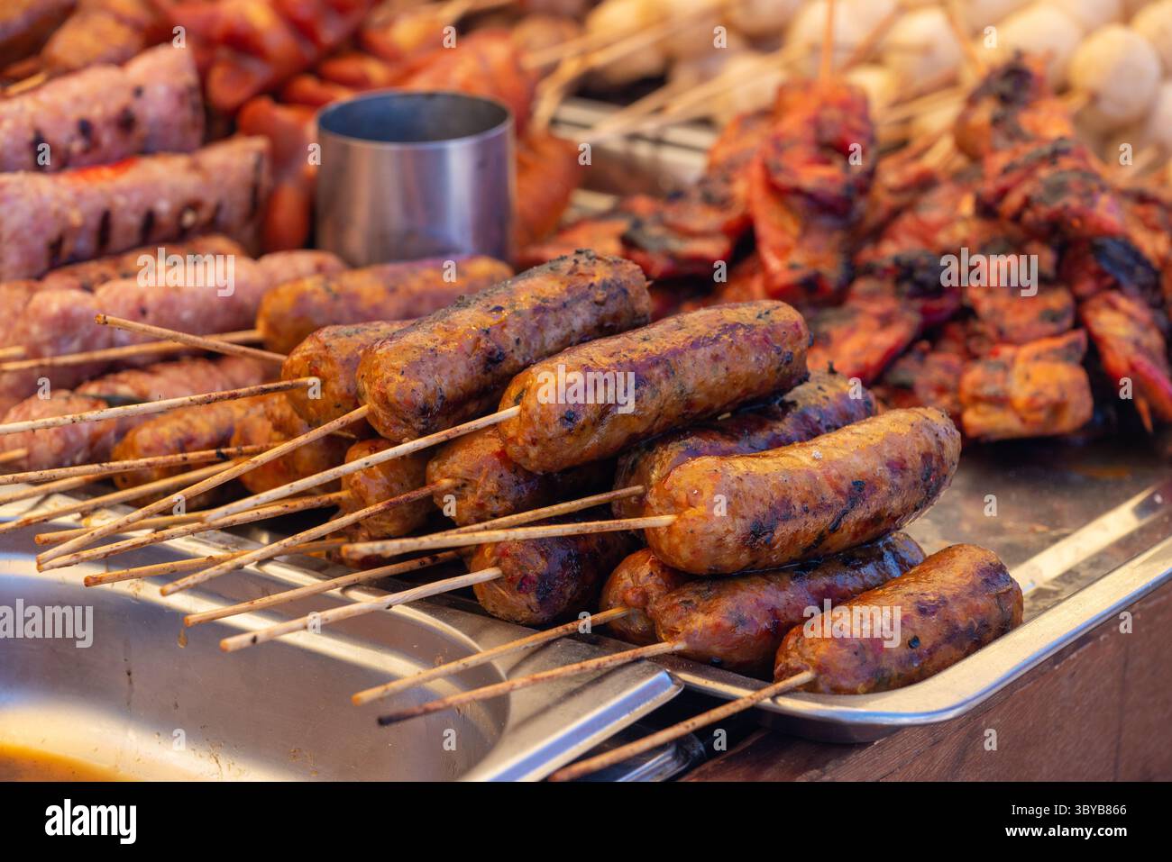 Thai street food, different meats and sausages on sticks. All on ...