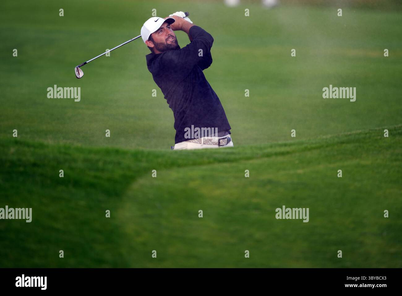USA's Scottie Scheffler chips out of a bunker on the 12th during day ...