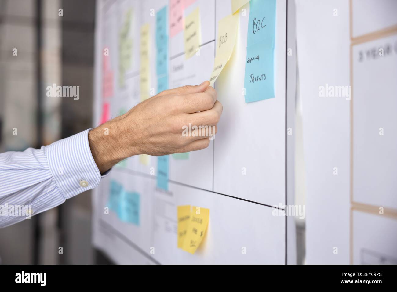 Project manager attaching sticky hi-res stock photography and images ...