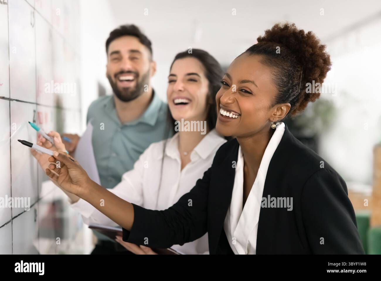 Three smiling colleagues engaged in positive teamwork Stock Photo - Alamy