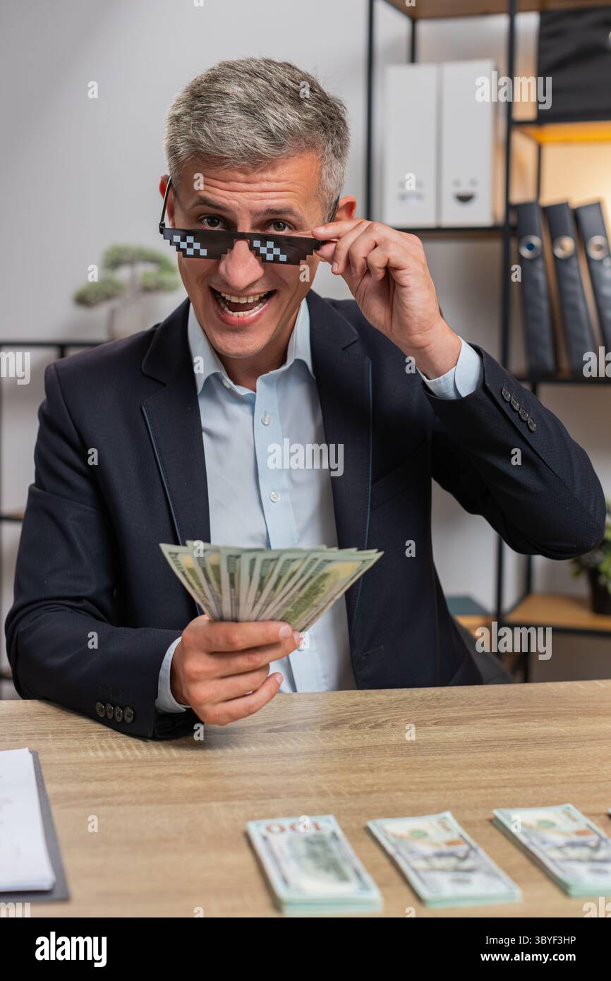 Happy rich Caucasian young businessman winner counting money cash ...