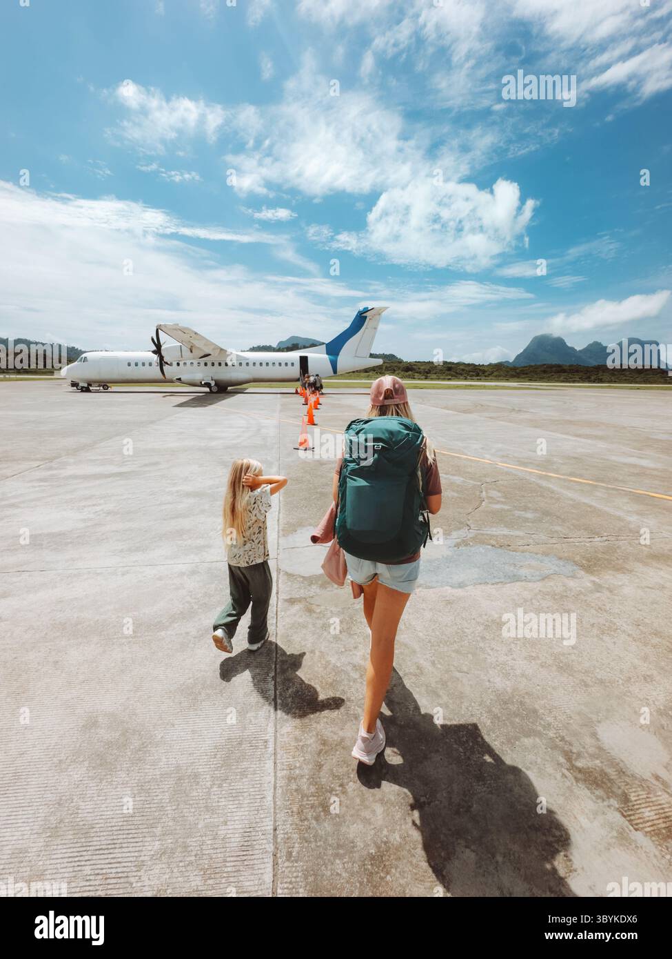 Family travel - mom and child at the airport boarding an airplane ...