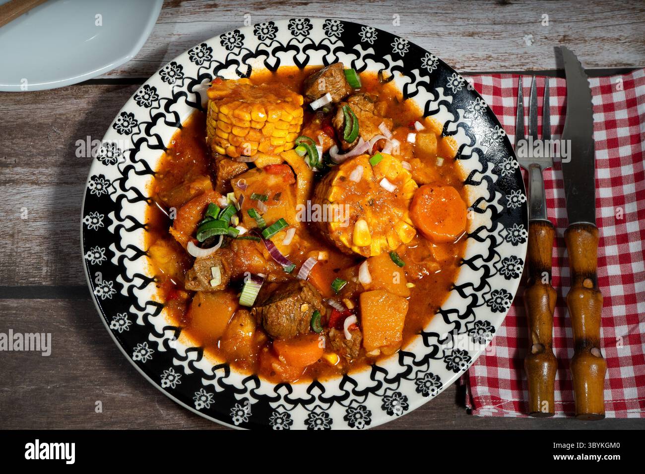 Delicious homemade beef stew served with corn on the cob, accompanied ...